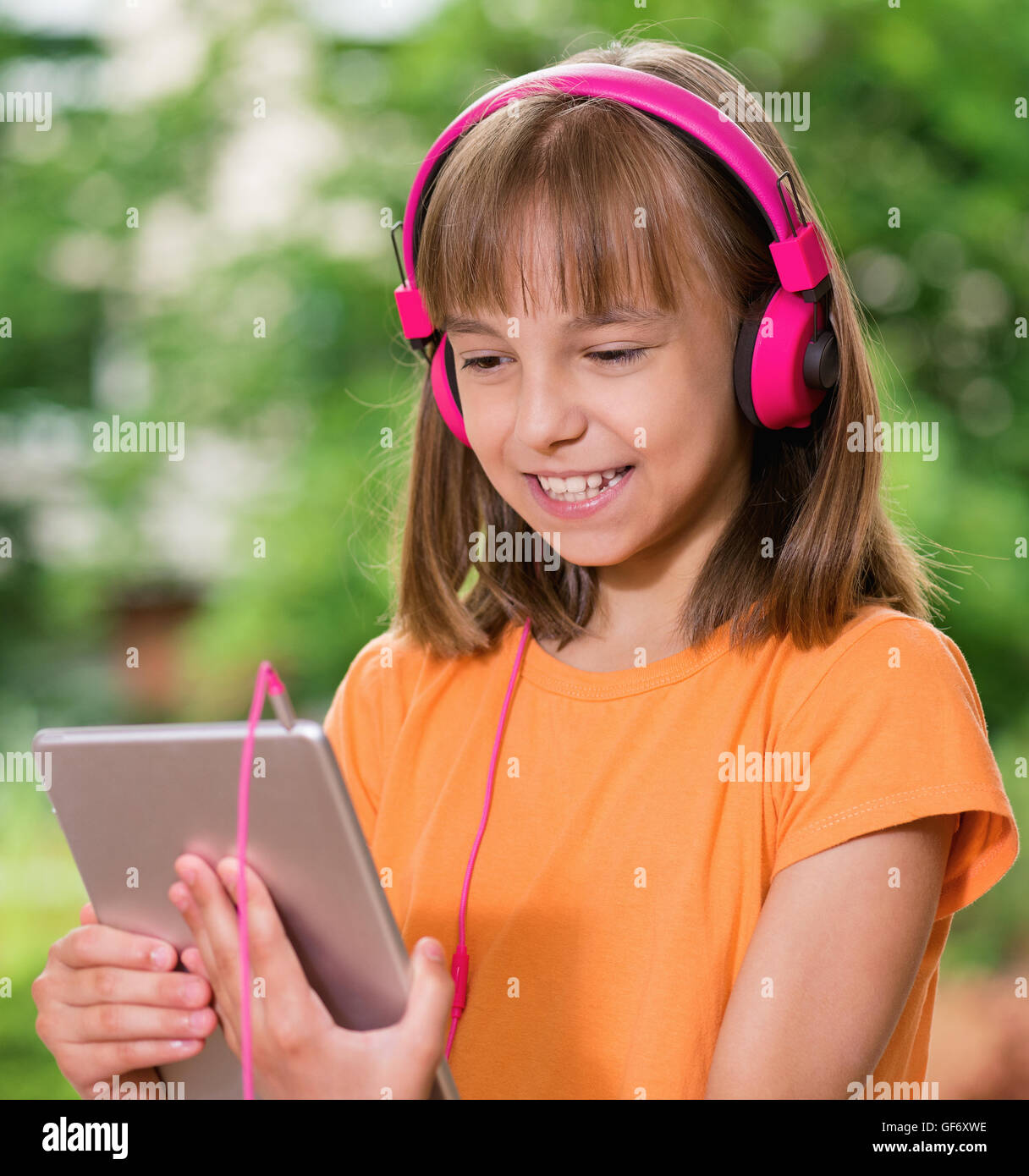 Girl with tablet and headphones Stock Photo - Alamy