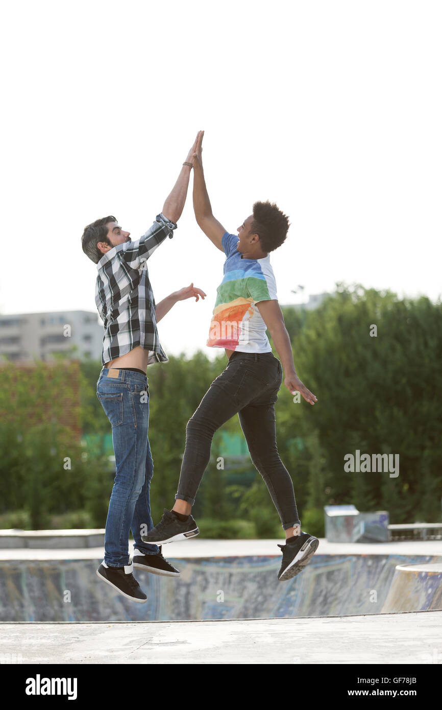 Young happy men jumping and clap hands in the air Stock Photo - Alamy