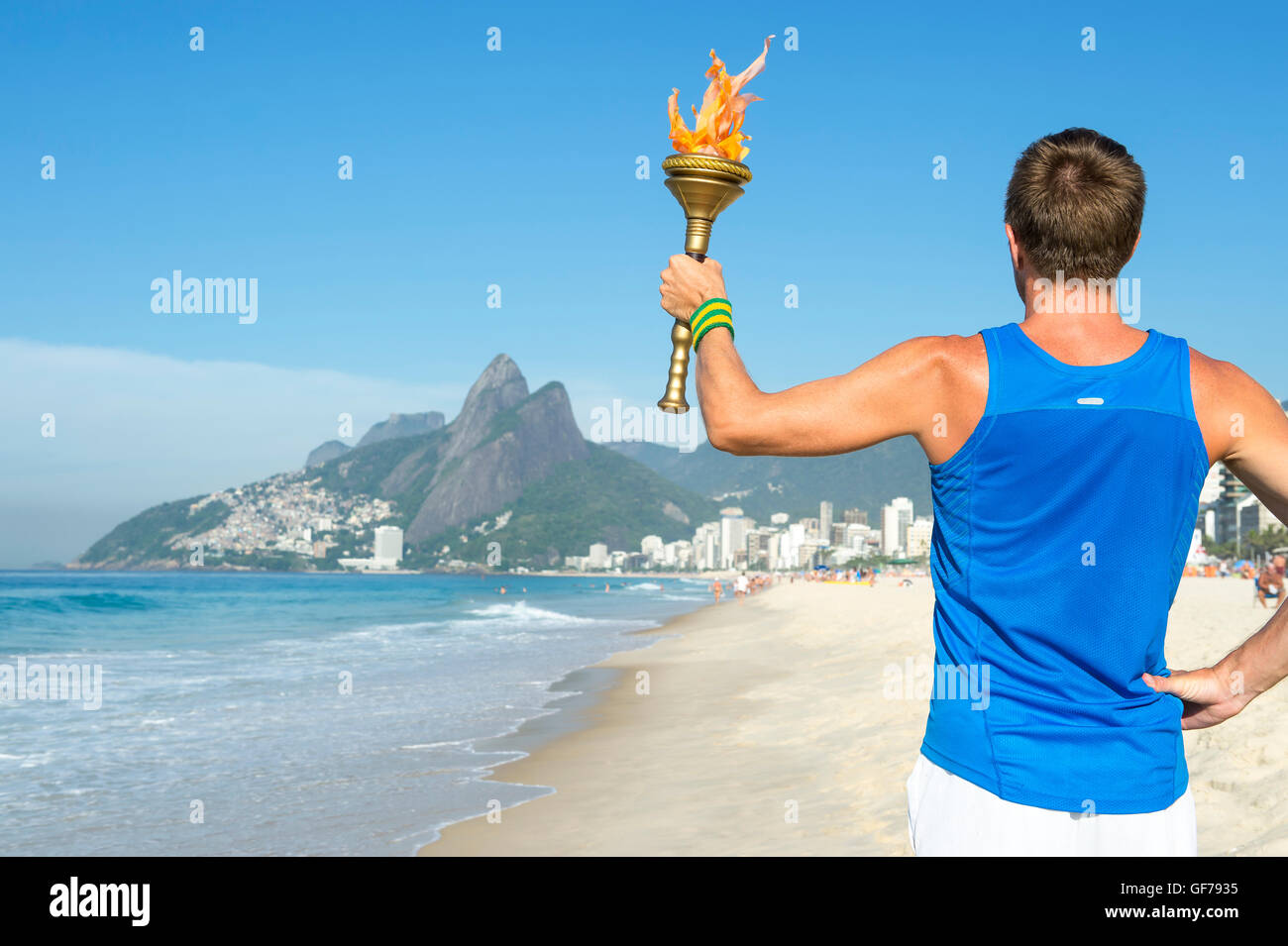 Torchbearer athlete standing with sport torch above the Rio de Janeiro ...