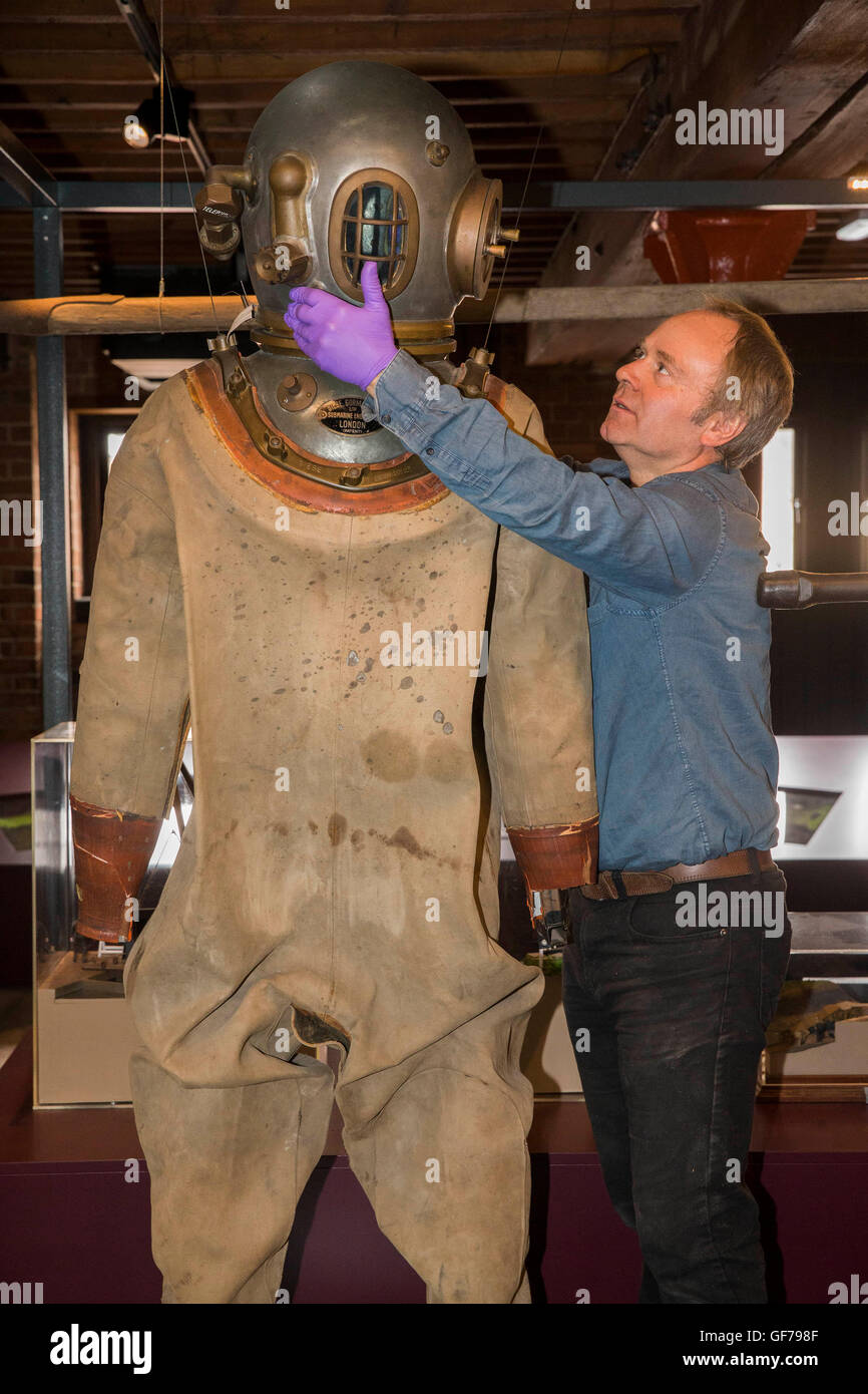 EDITORIAL USE ONLY Steve Bagley adjusts the helmet of a dive suit ...