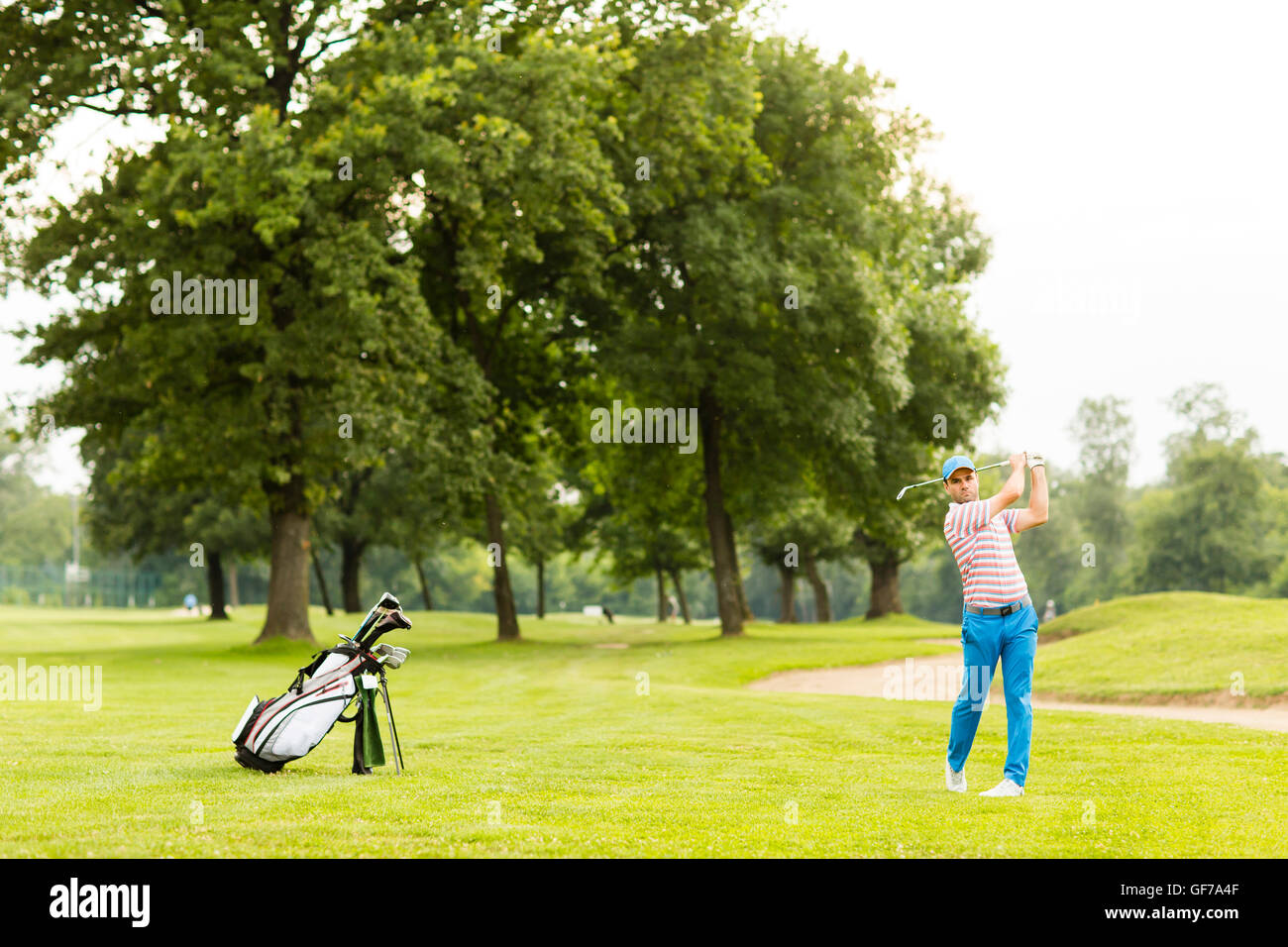 Young man playing golf on the golf course Stock Photo - Alamy