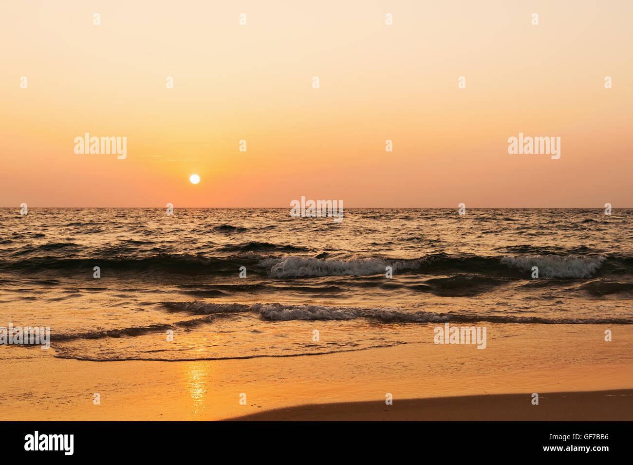 Beach sunrise of the sea with sky in twilight over light the sun and at ...