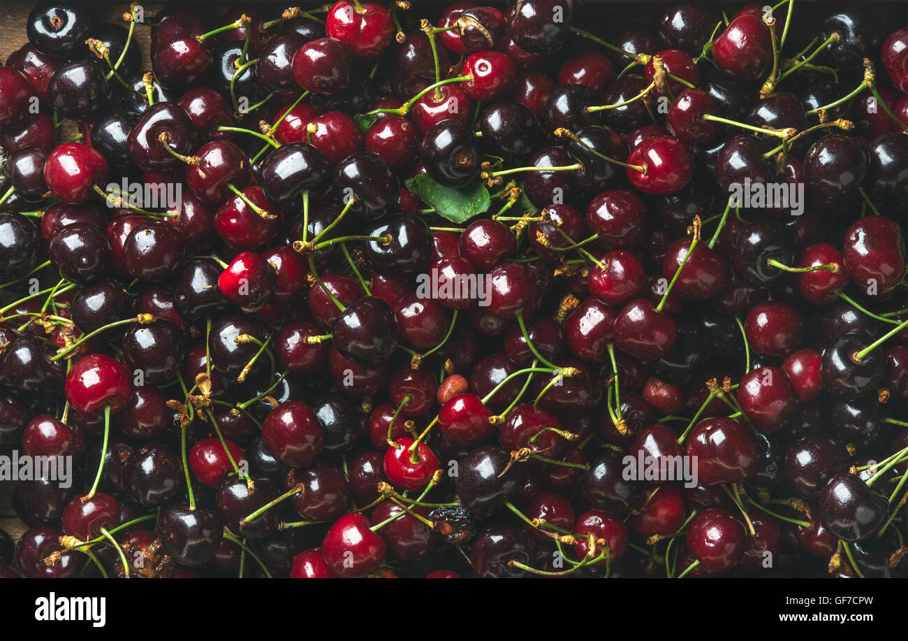 Background of dark red sweet cherries over wooden backdrop Stock Photo ...