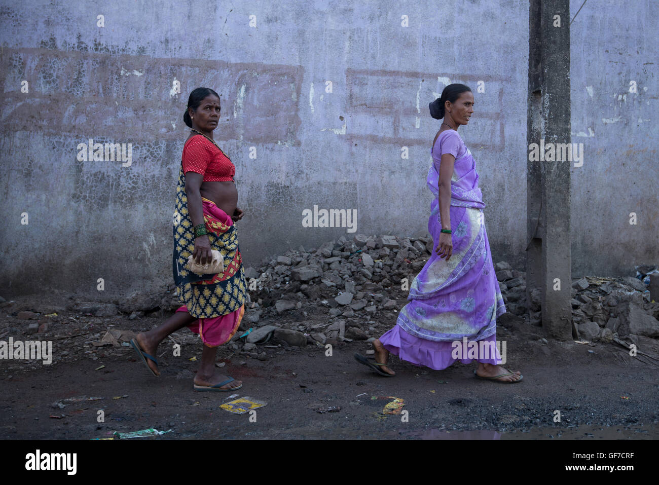 Local Indian women at sunrise walking at Shirgaon village street ...