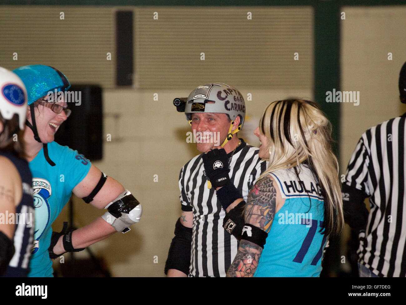 Male roller derby referee smiles with female skaters laughing Stock ...