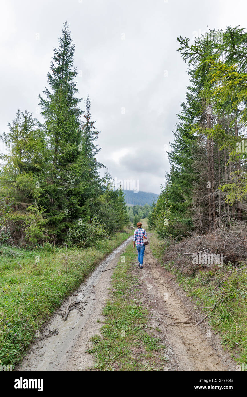 White woman hiking dirty rural forest road in Carpathian mountains, Western Ukraine Stock Photo ...