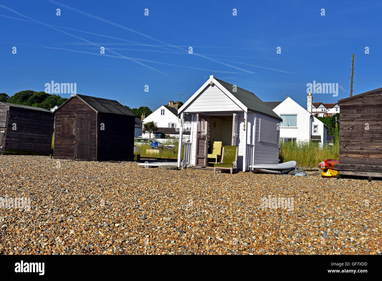 Beach huts at the top of a shingle beach, on the Kent coast where it ...