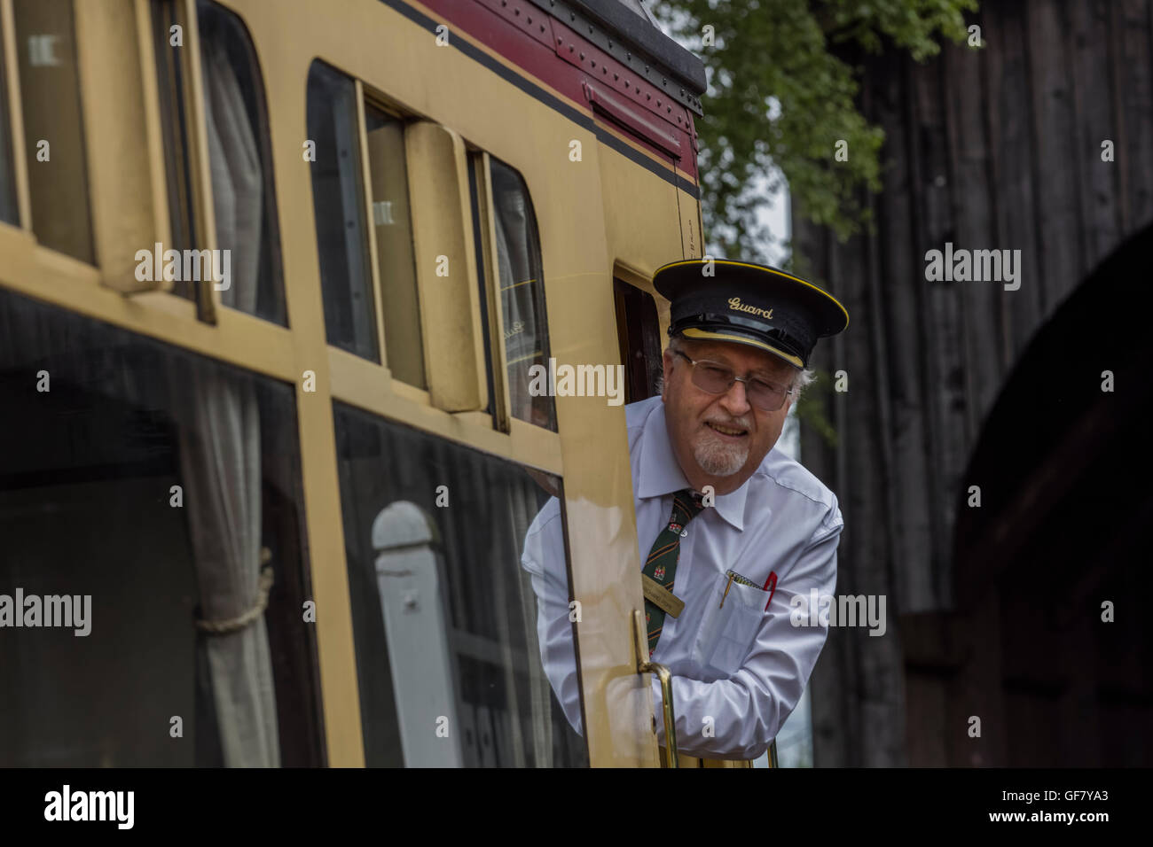 Train guard looks out the window of the train carriage as the train ...