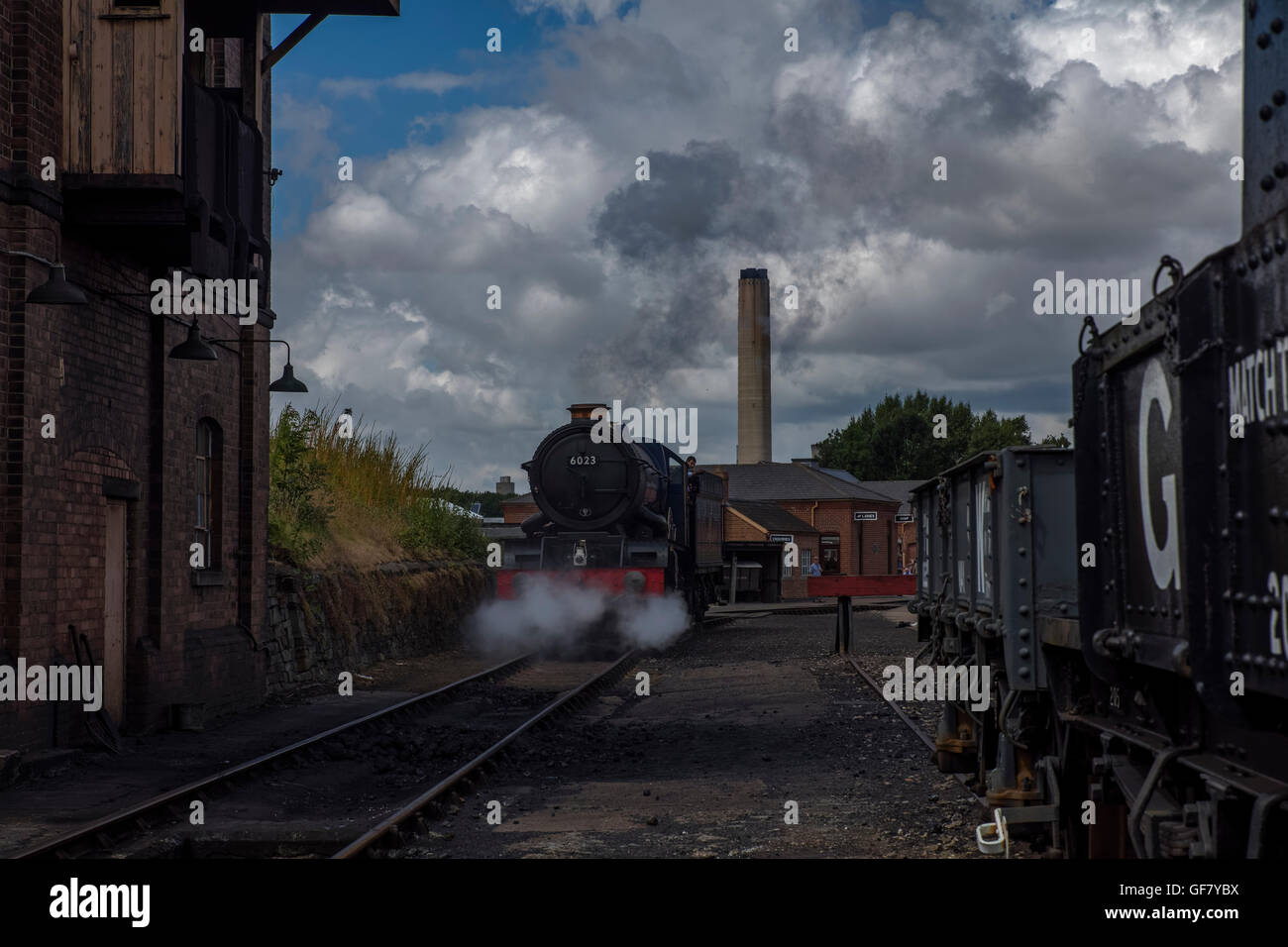 Steam locomotive with steam from its funnel and wheels advancing ...