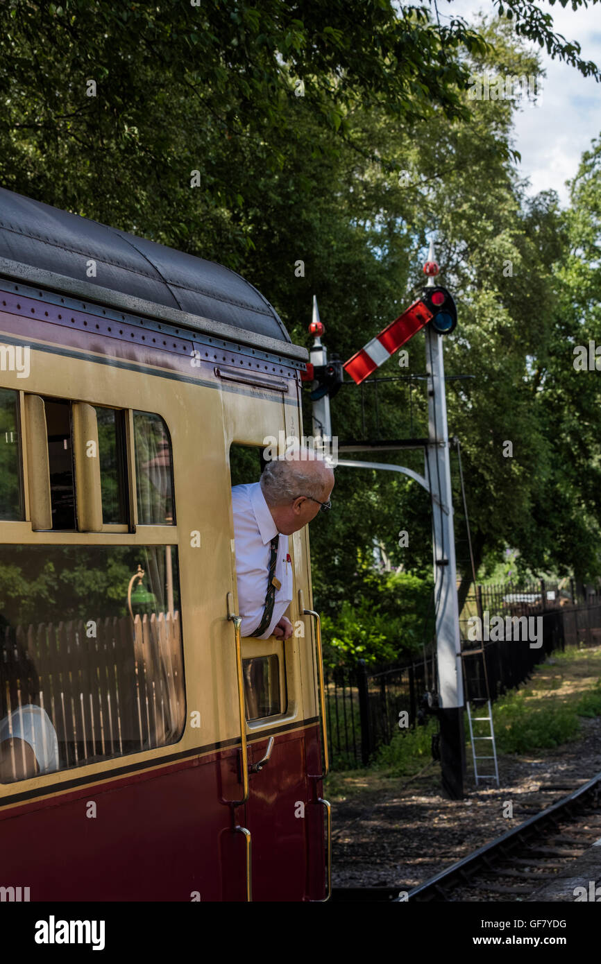 Train guard looks out the window of the railway carriage towards the ...