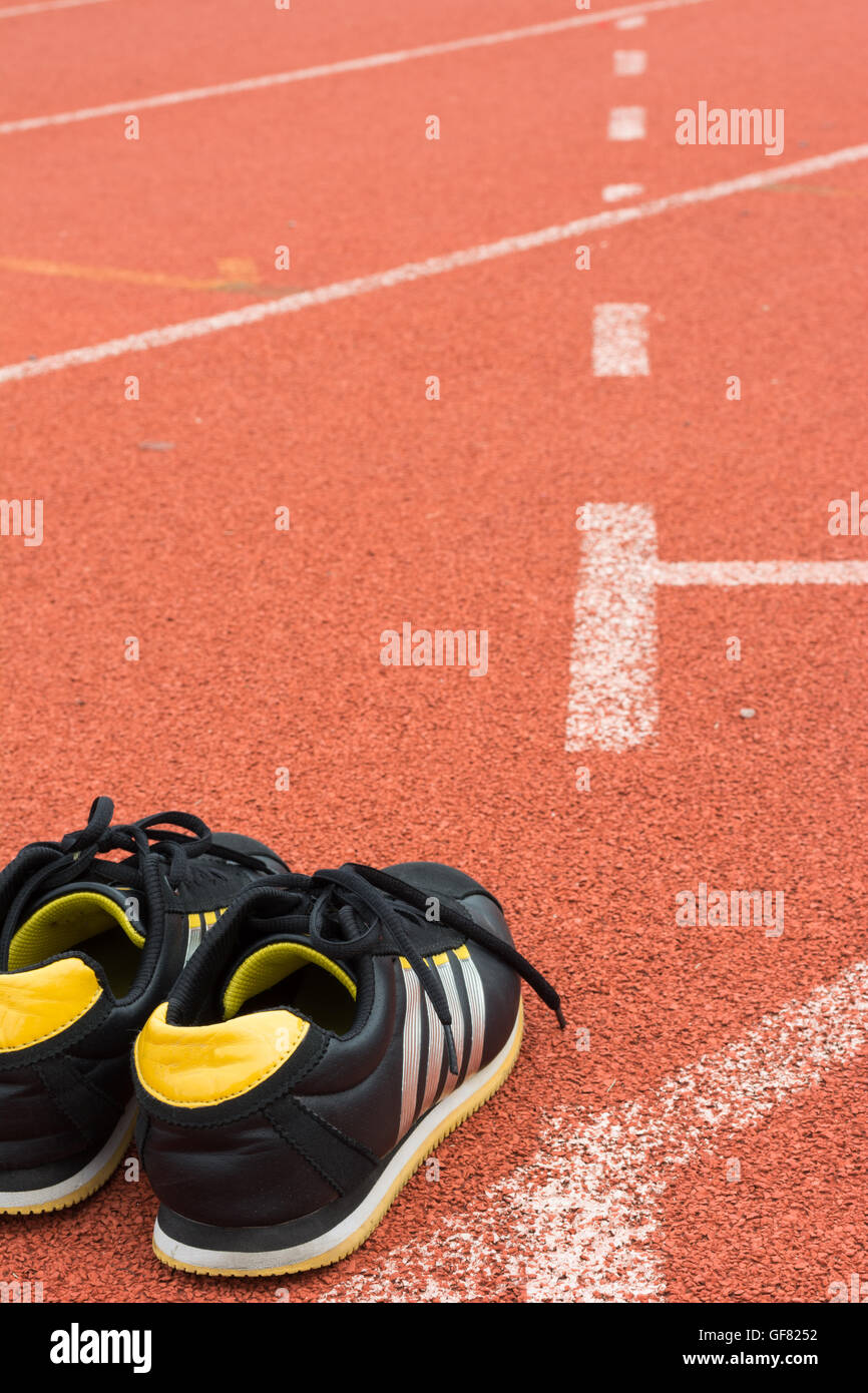 Sport shoes on running track background Stock Photo - Alamy