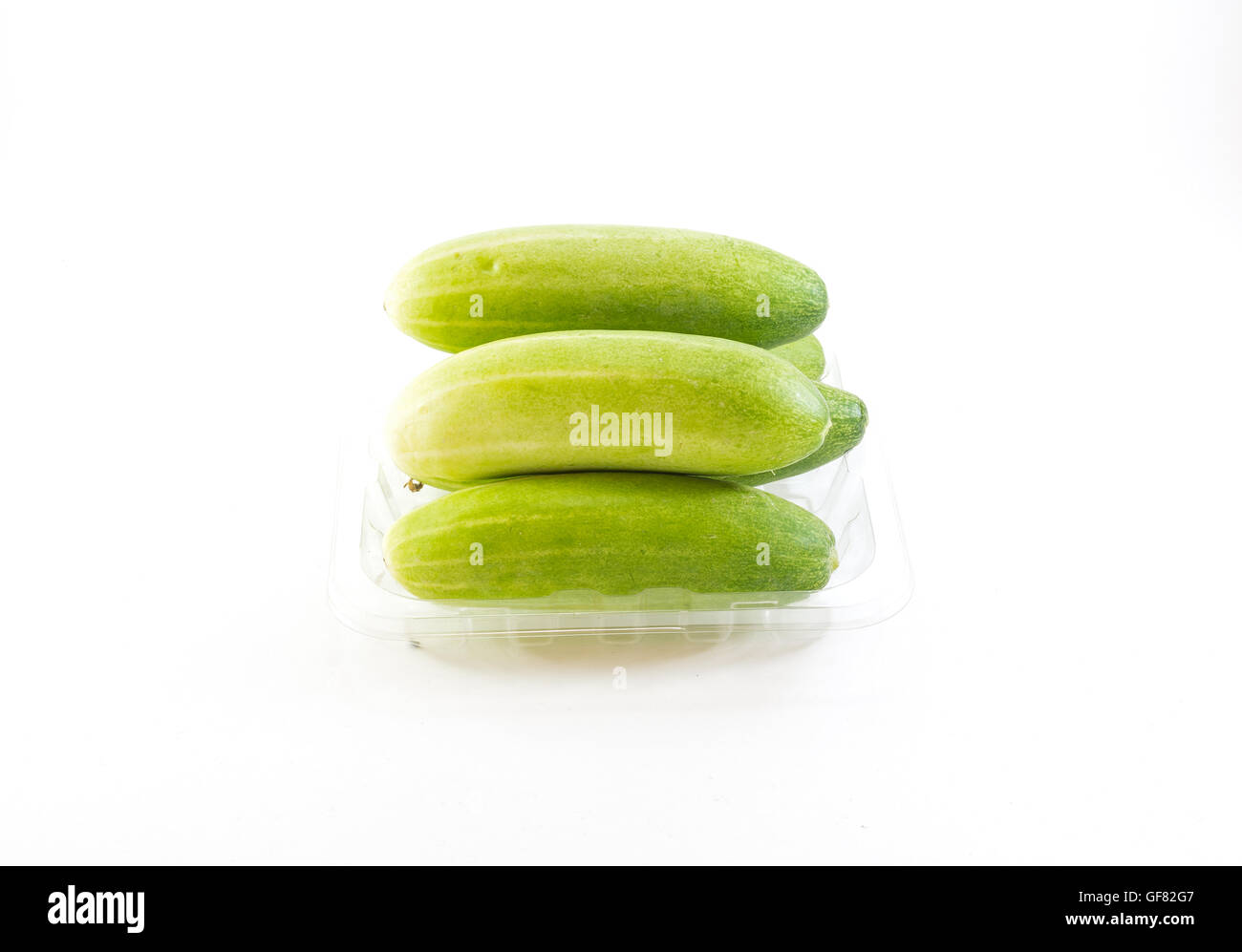 Five green cucumbers stack in plastic tray on white background Stock ...