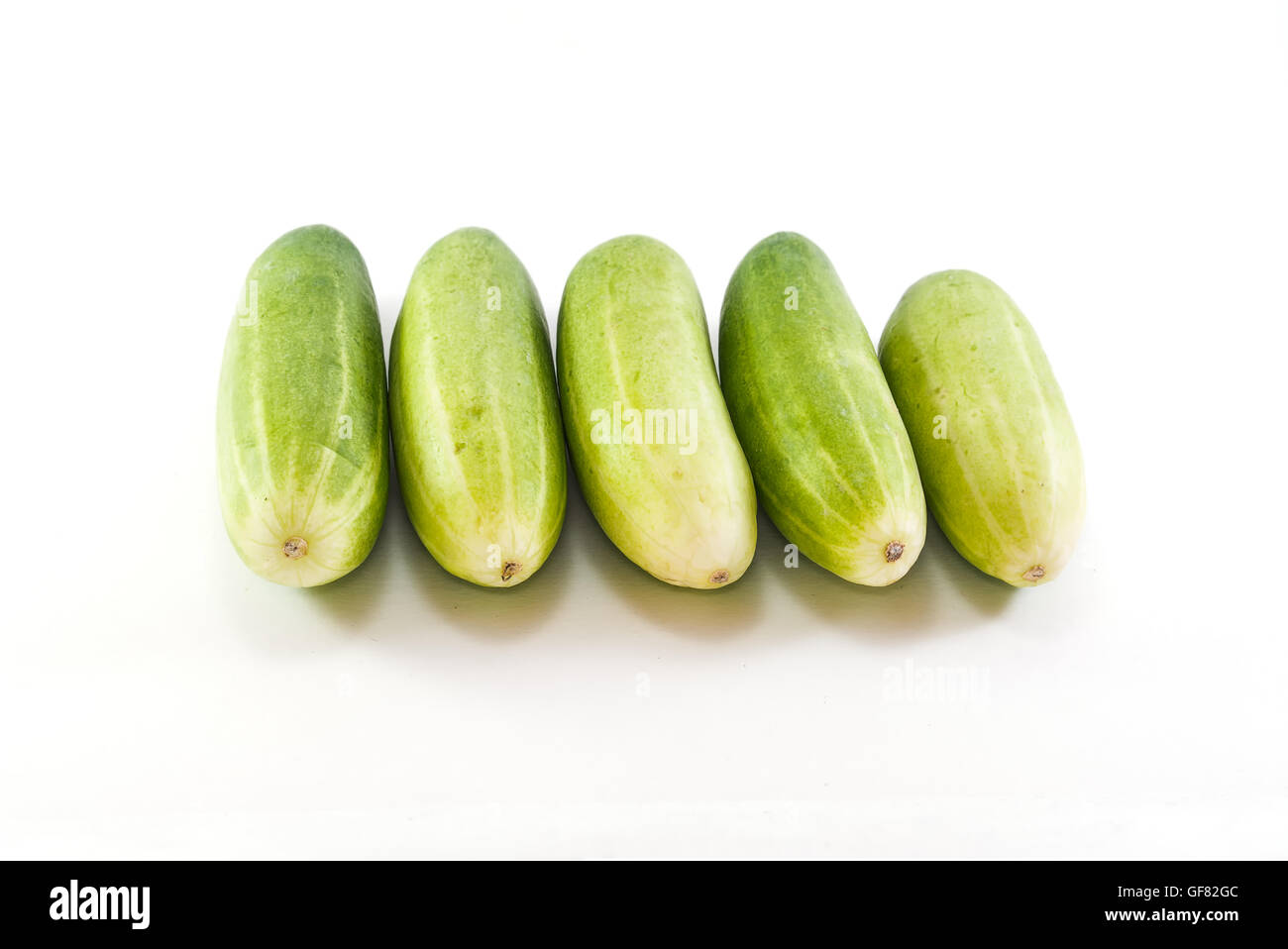 Five green cucumbers in on white background Stock Photo - Alamy