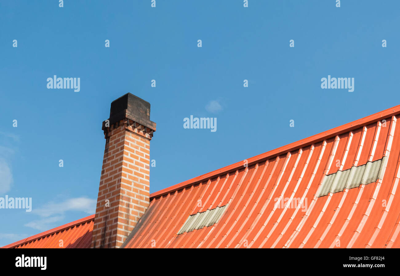 Chimney with roof tiles, Orange on blue sky background Stock Photo - Alamy