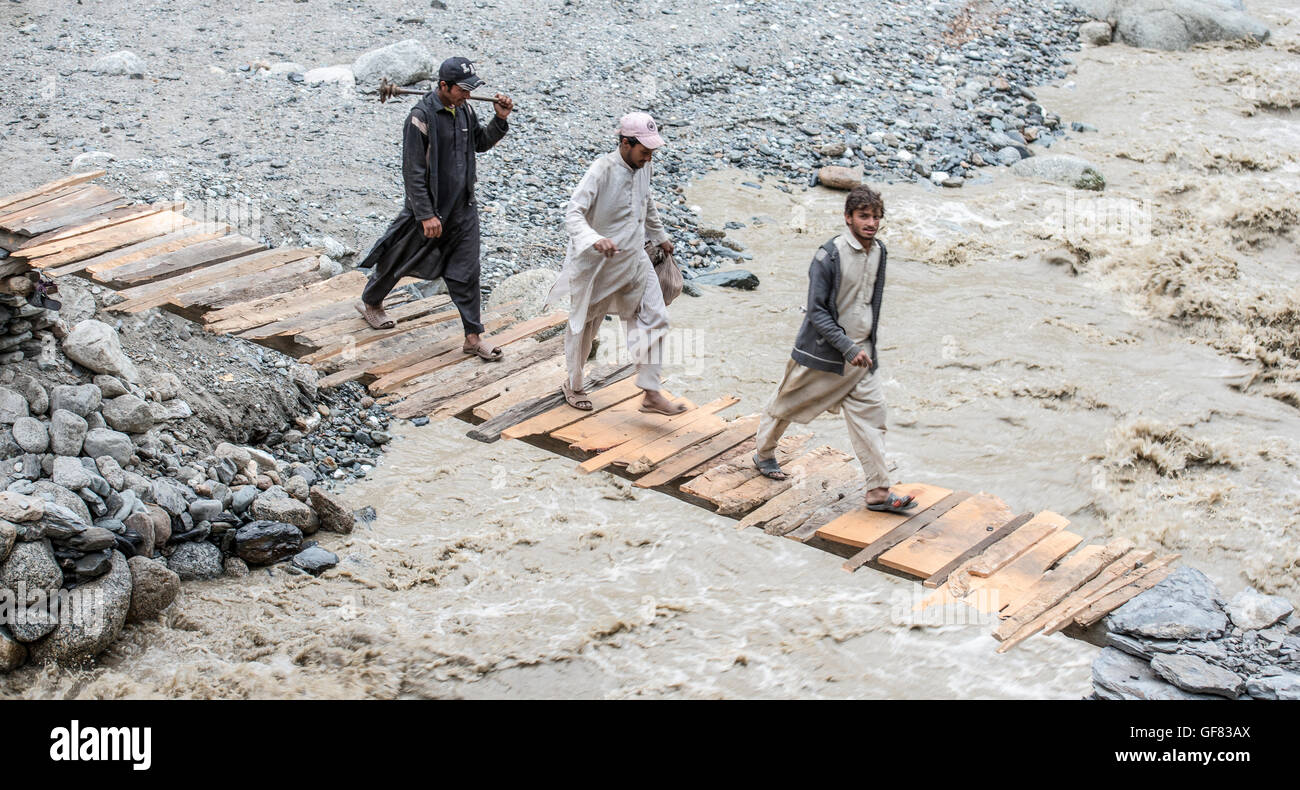 Three Kalash men crossing a footbridge in Pakisitan Stock Photo - Alamy