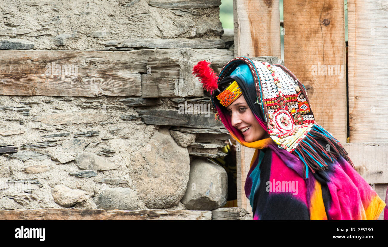 Kalash woman wearing a traditional cowrie shell headdress and a ...