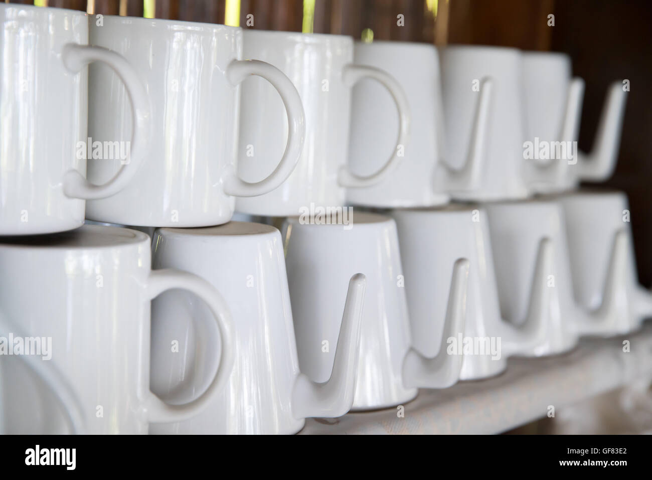 white cups stack on shelf with sunlight Stock Photo - Alamy