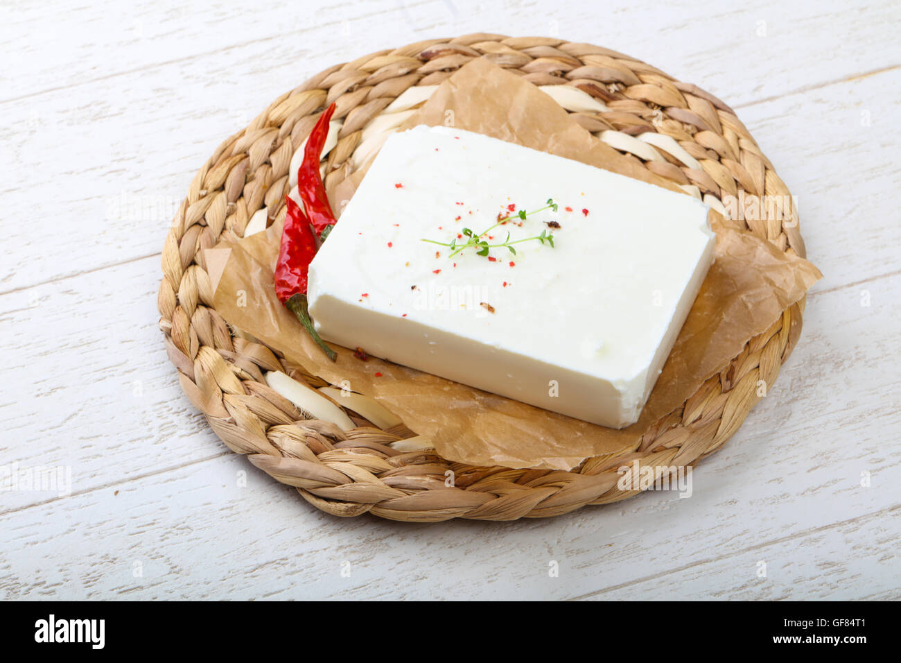 Feta brick cheese on the board wth thyme and pepper Stock Photo - Alamy