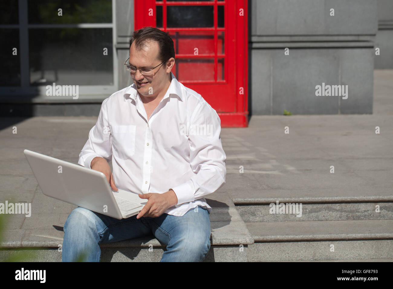 Business man using mobile phone red classic English telephone box Stock ...