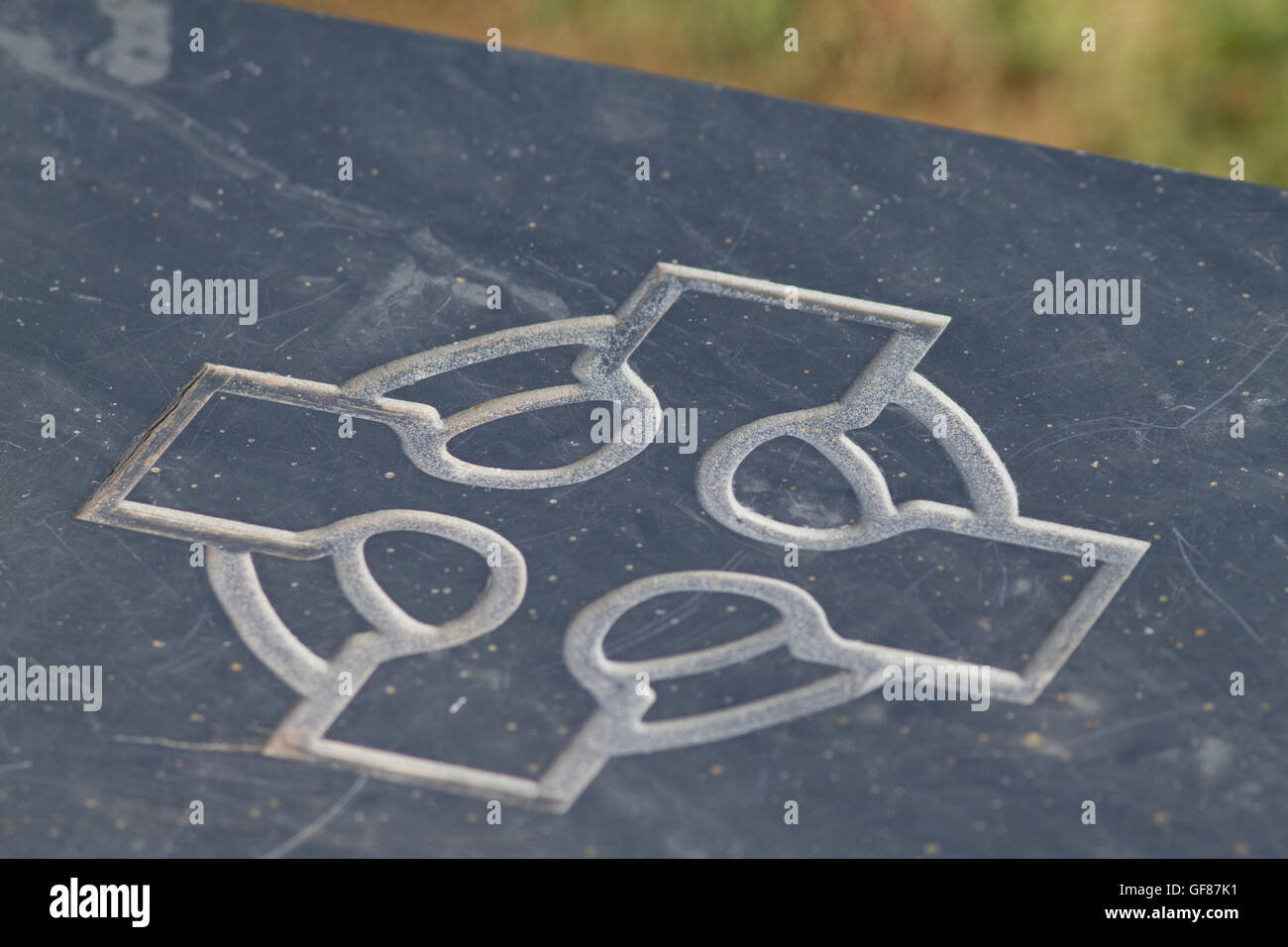 Celtic cross symbol on a slate, stone bench on the cliff-top ...