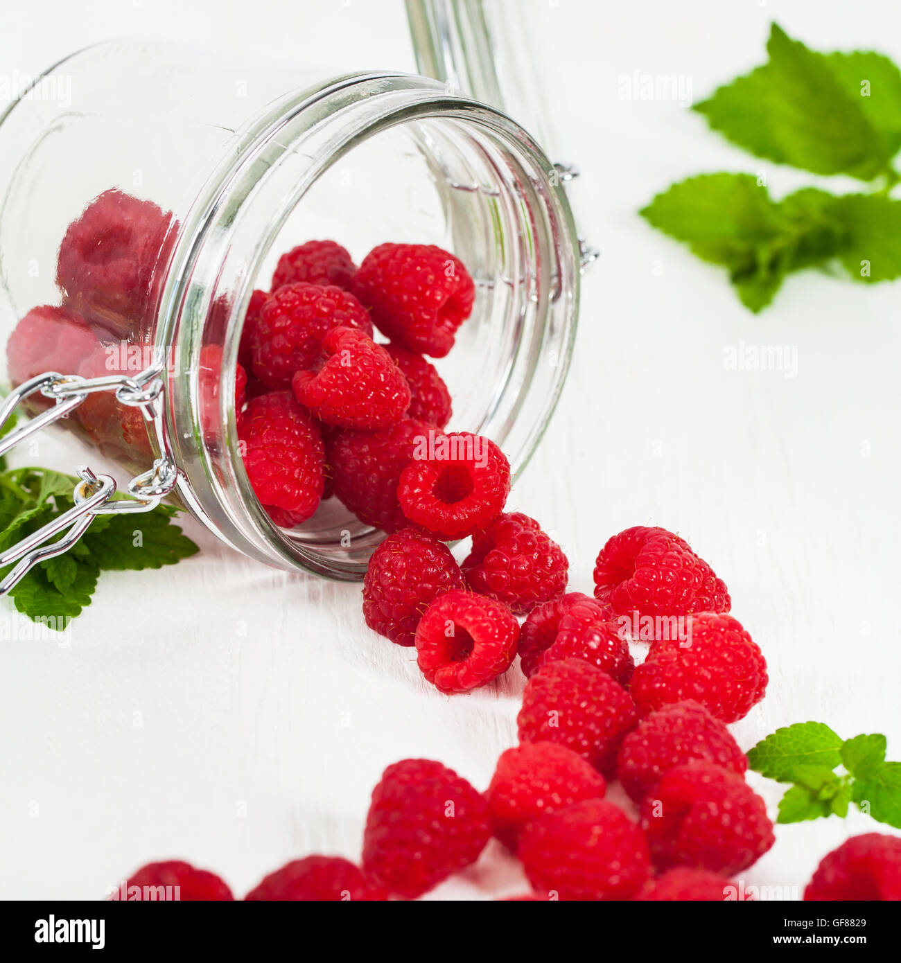 Ripe raspberry with green leaf background Stock Photo - Alamy