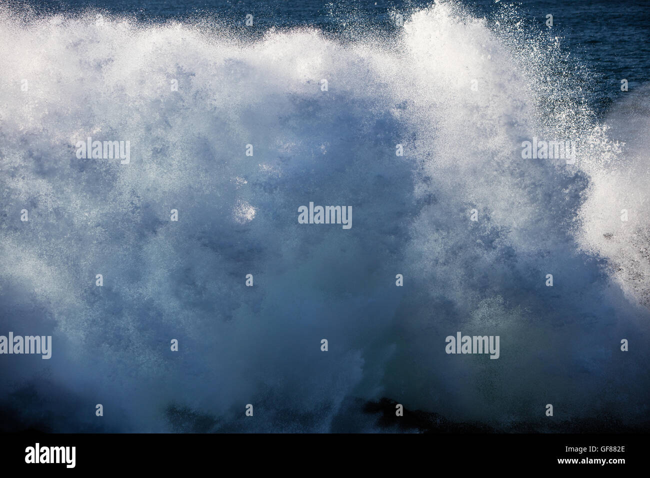 A massive wave from the Pacific Ocean crashes powerfully against the ...