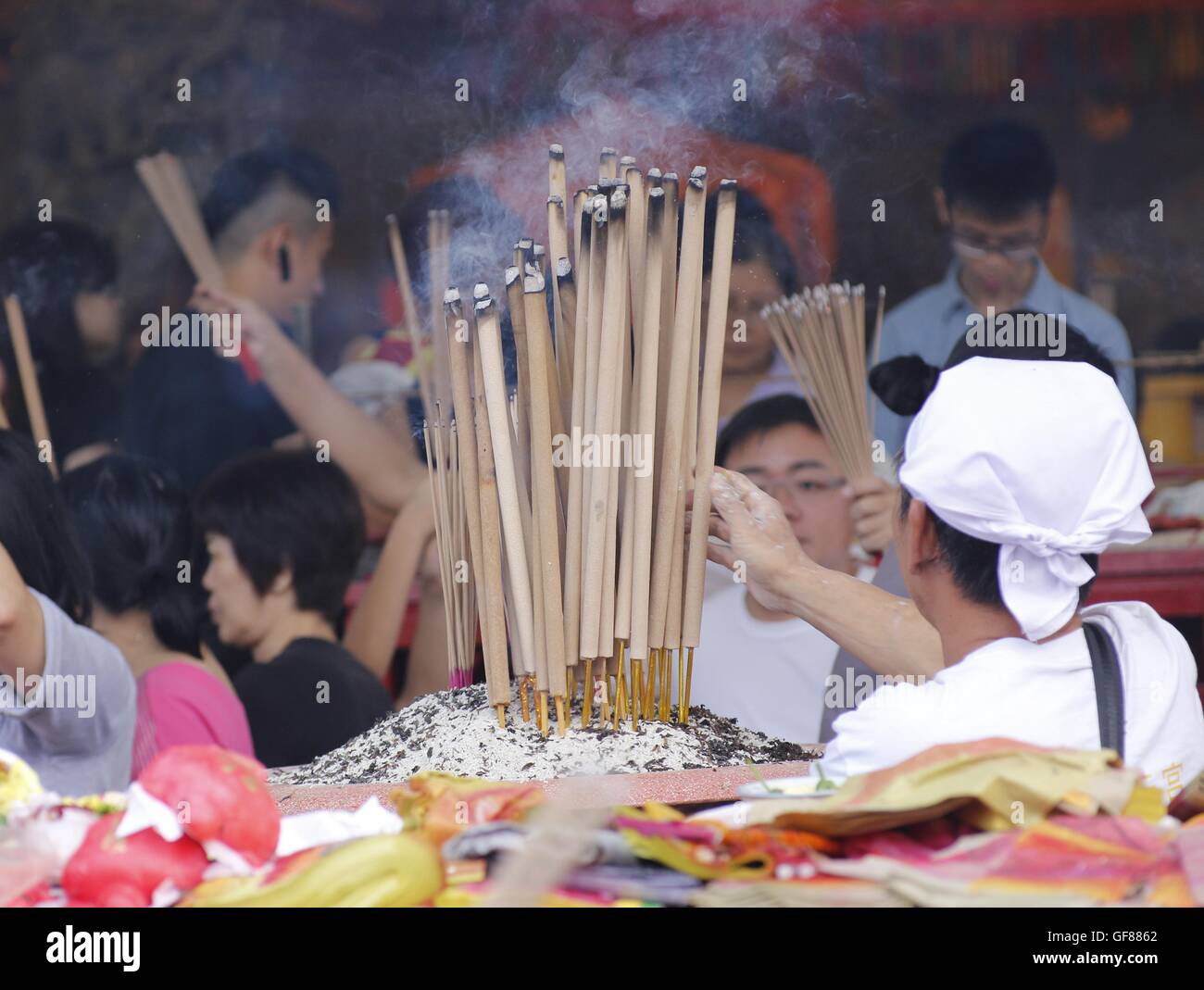 Taoist devotees praying with joss sticks at temple Stock Photo - Alamy
