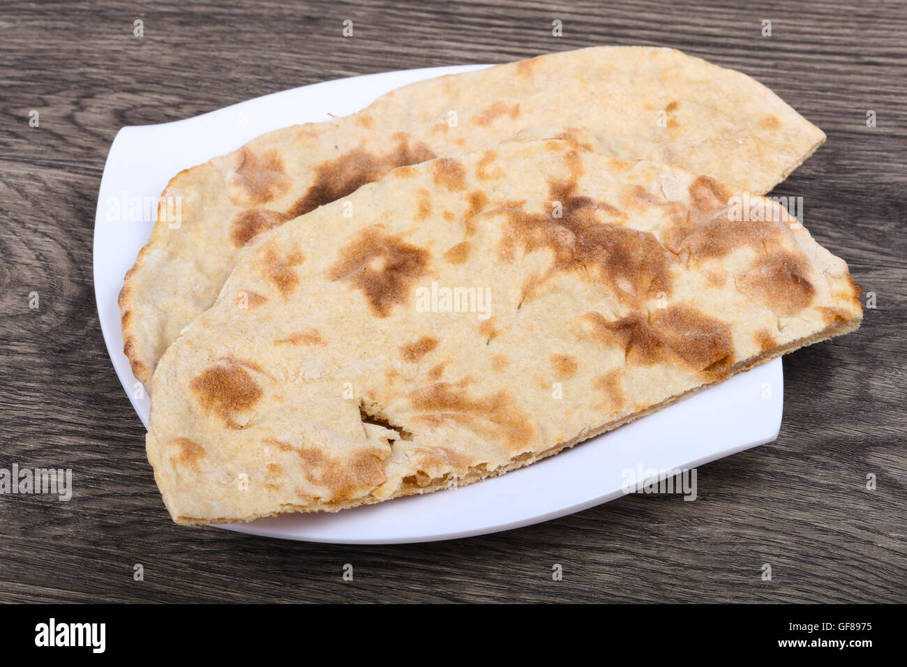 Indian bread naan in the plate on wood background Stock Photo - Alamy