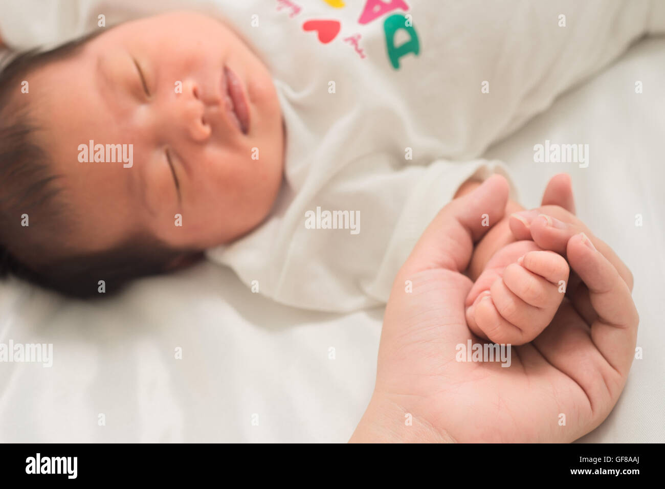 Baby sleeping in bed finger hi-res stock photography and images - Alamy