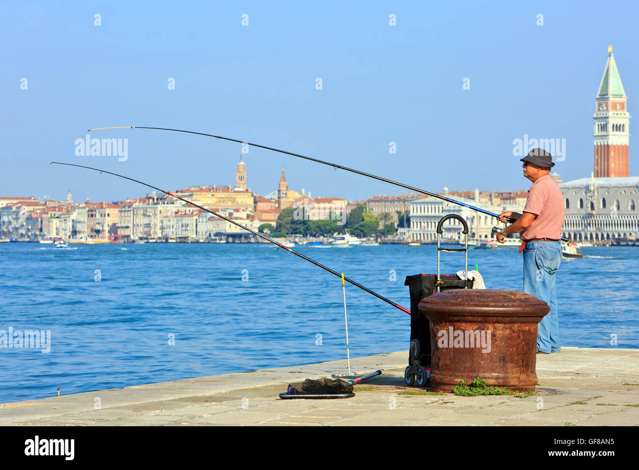 An angler fishing with a view at the Doge's Palace and Saint Mark's ...