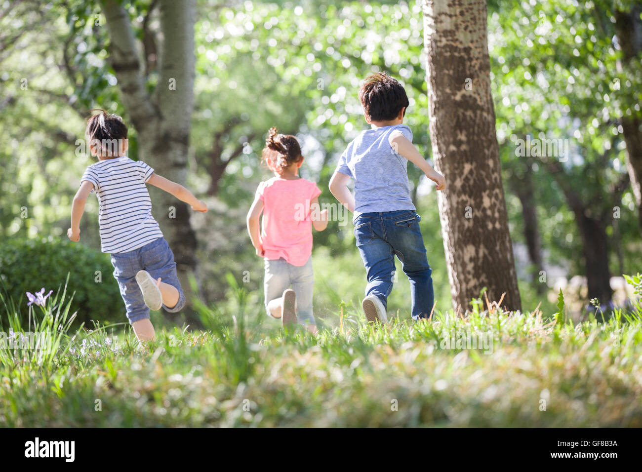 Happy Chinese children racing in woods Stock Photo - Alamy