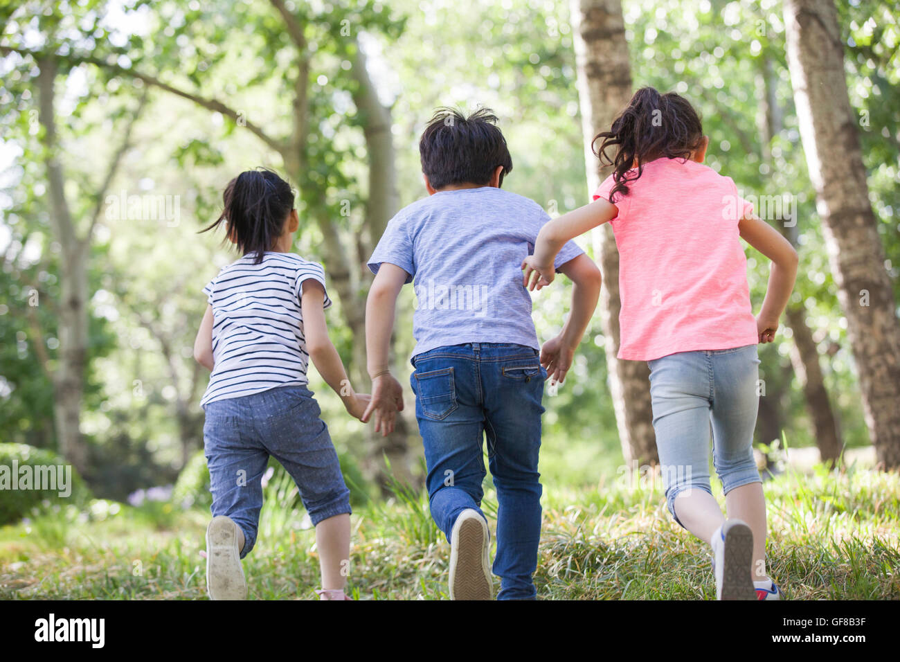 Happy Chinese children racing in woods Stock Photo - Alamy