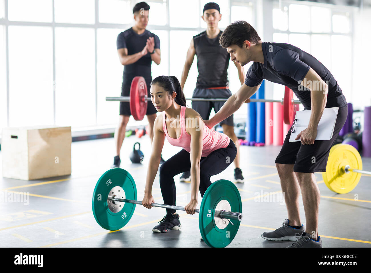 Young Chinese woman working with trainer at gym Stock Photo - Alamy