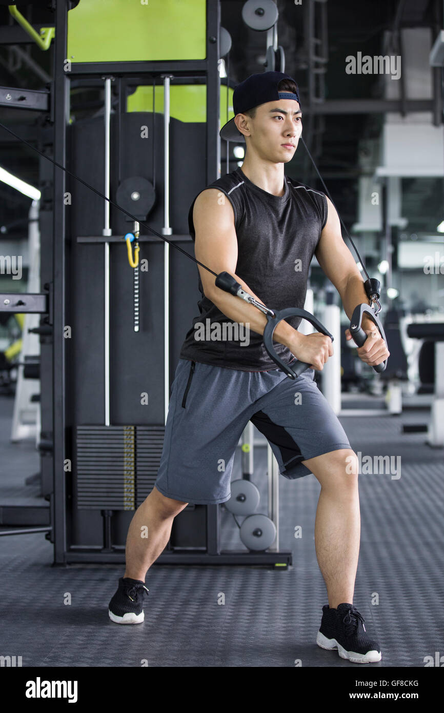 Young Chinese man using exercise machine at gym Stock Photo - Alamy