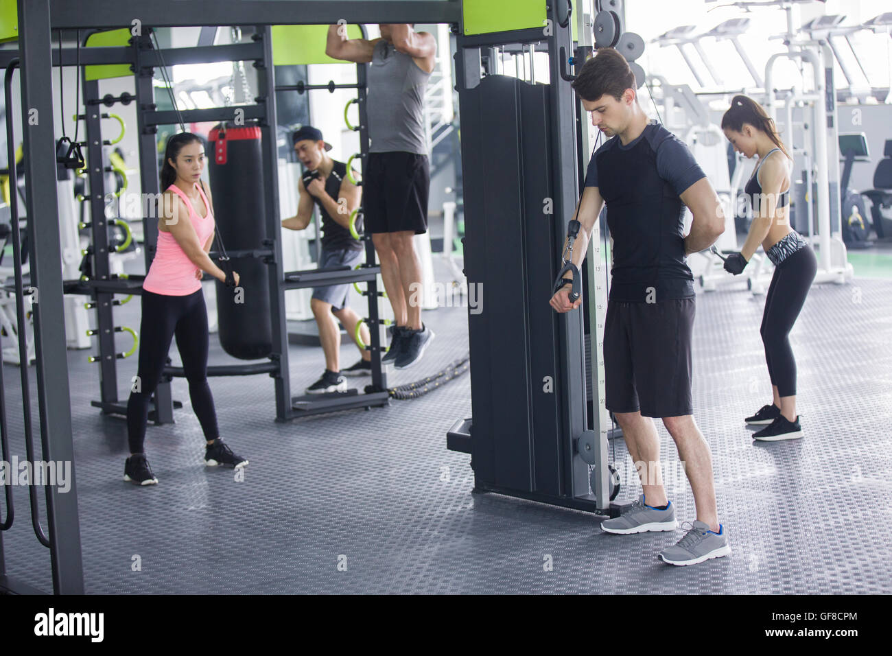 Young adult using exercise machine at gym Stock Photo - Alamy