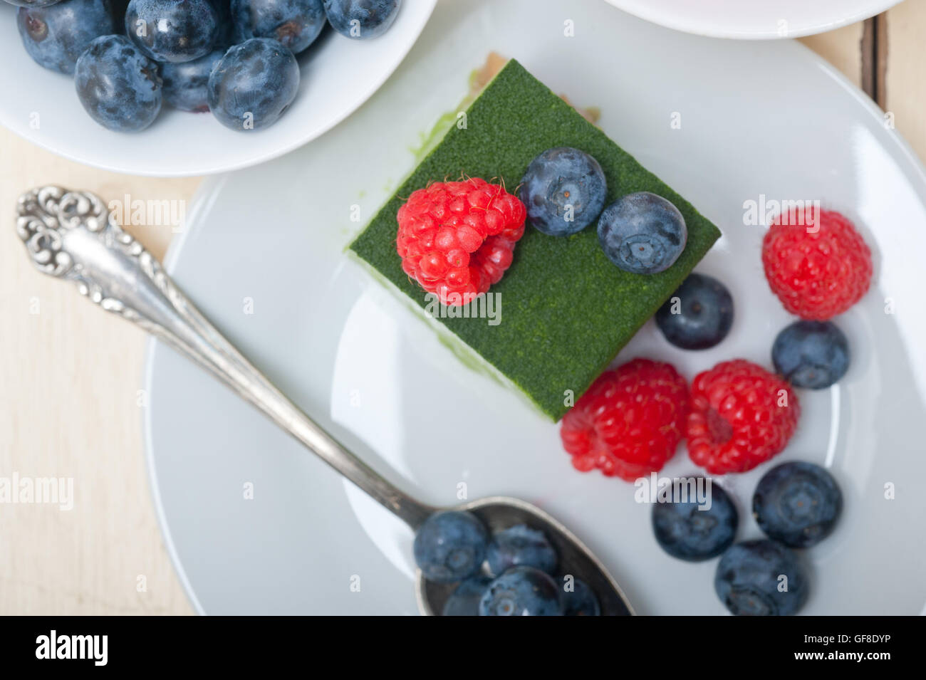 green tea matcha mousse cake with raspberries and blueberries on top ...