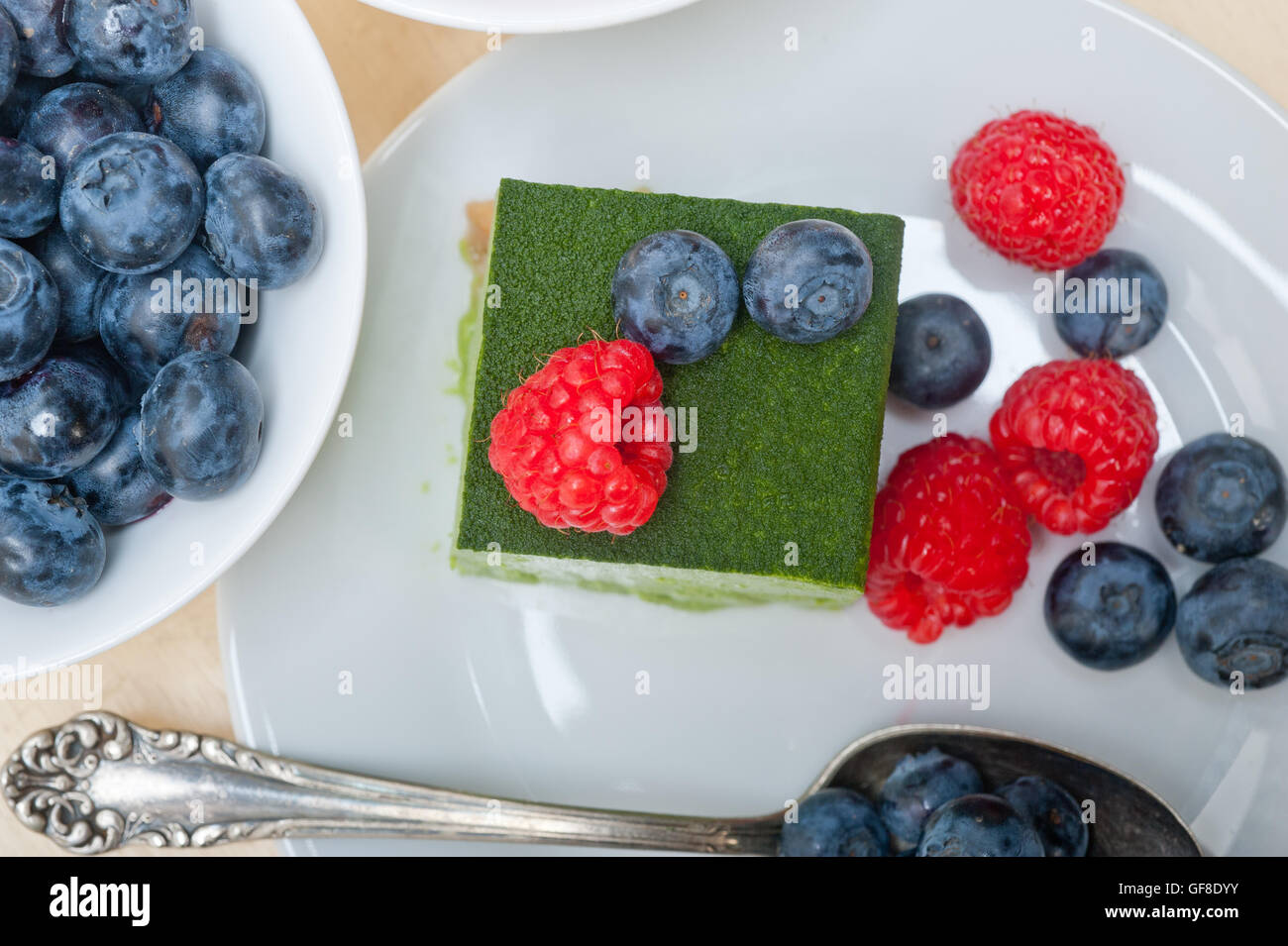 green tea matcha mousse cake with raspberries and blueberries on top ...