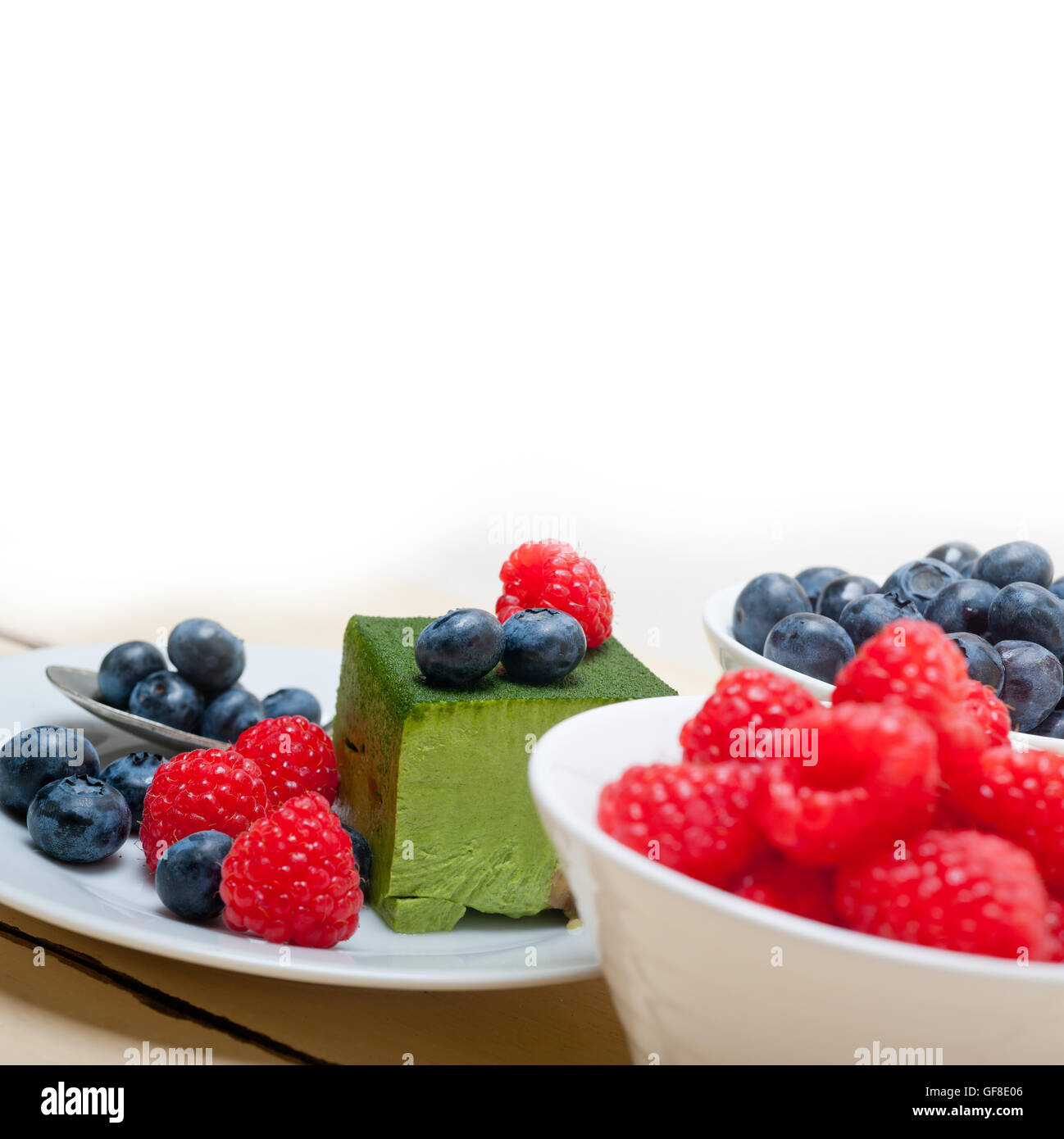 green tea matcha mousse cake with raspberries and blueberries on top ...