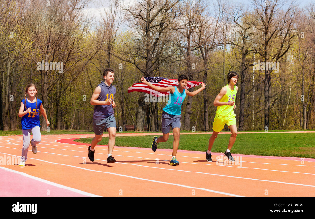 Four young sprinters waving American flag on track Stock Photo - Alamy