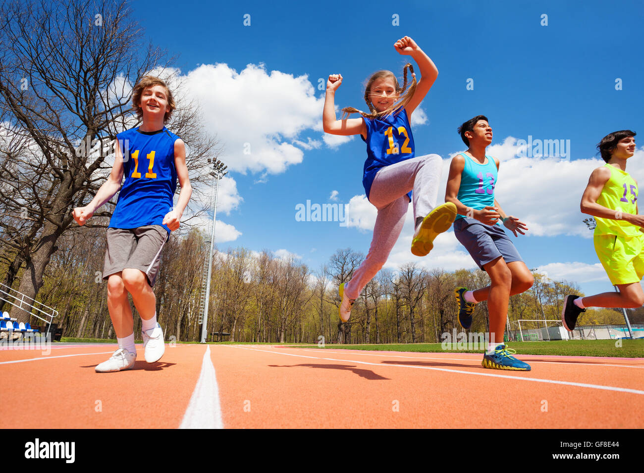 Happy teenage athletes running in the stadium Stock Photo - Alamy