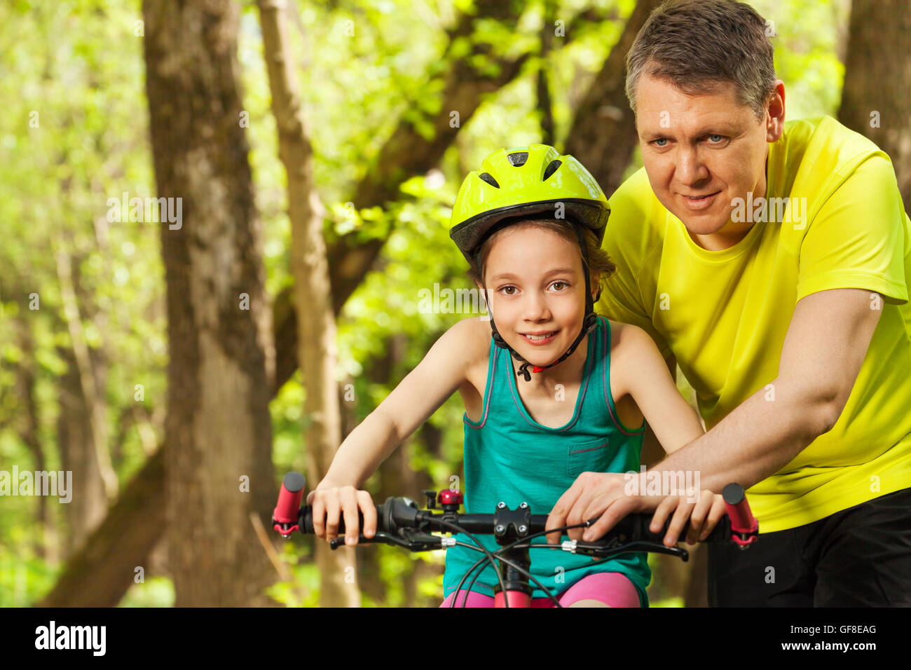 Happy girl learning to cycle with her father Stock Photo - Alamy