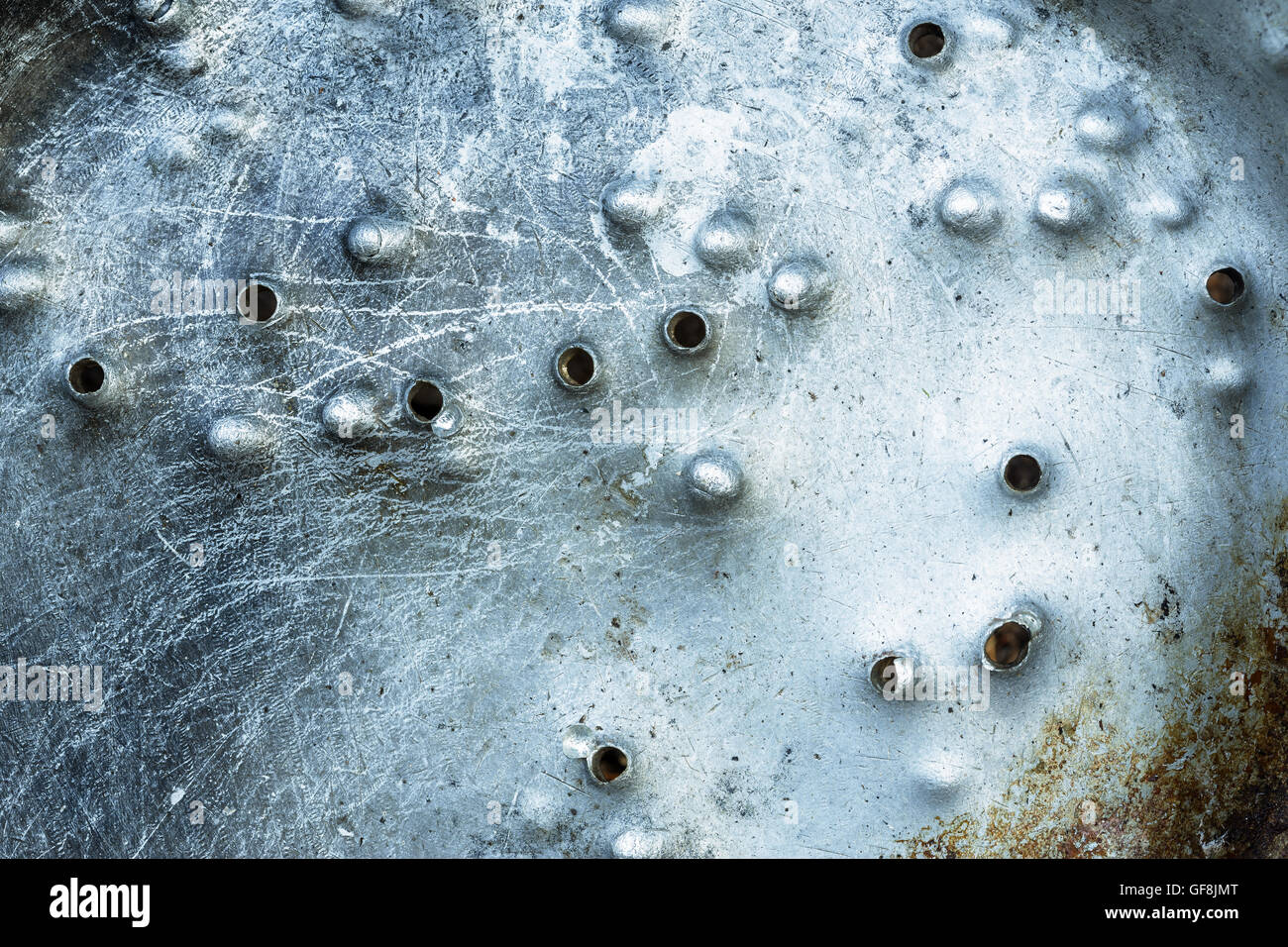 Metal surface with holes from bullets and shot Stock Photo - Alamy