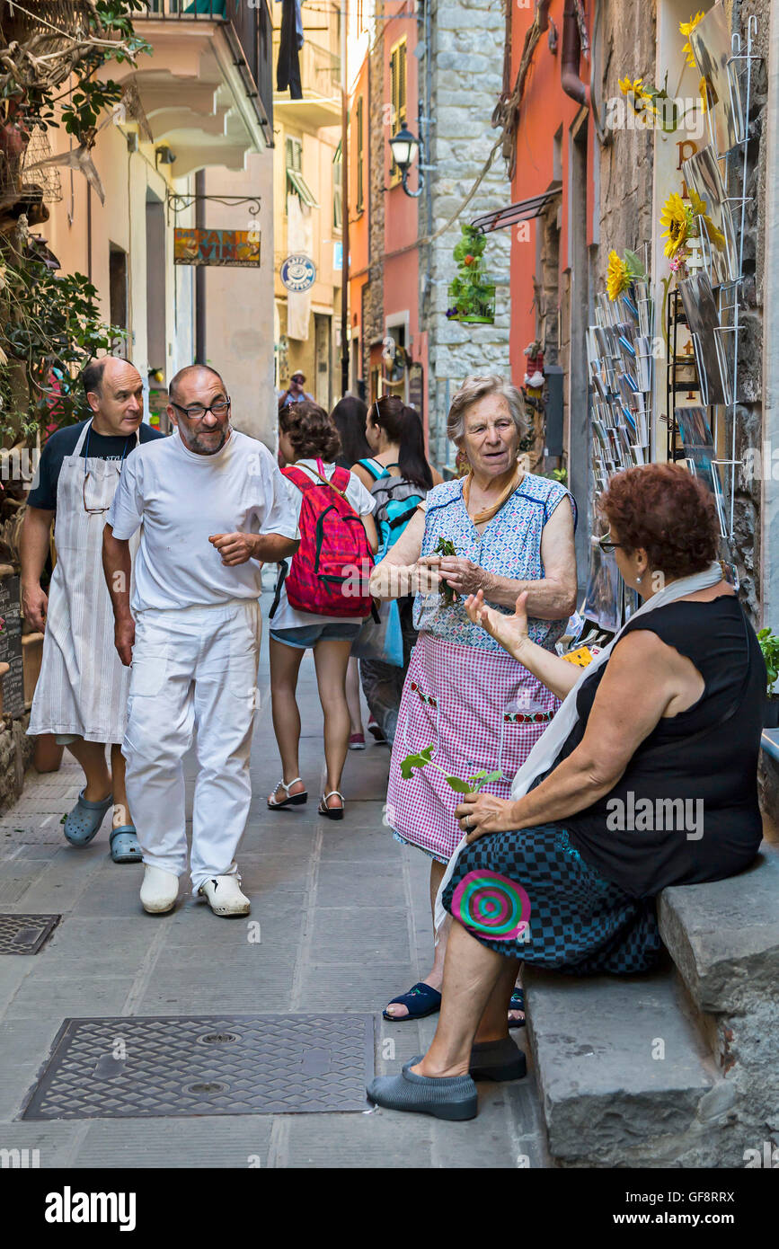 Local people on narrow street of colorful village of Corniglia, Cinque ...