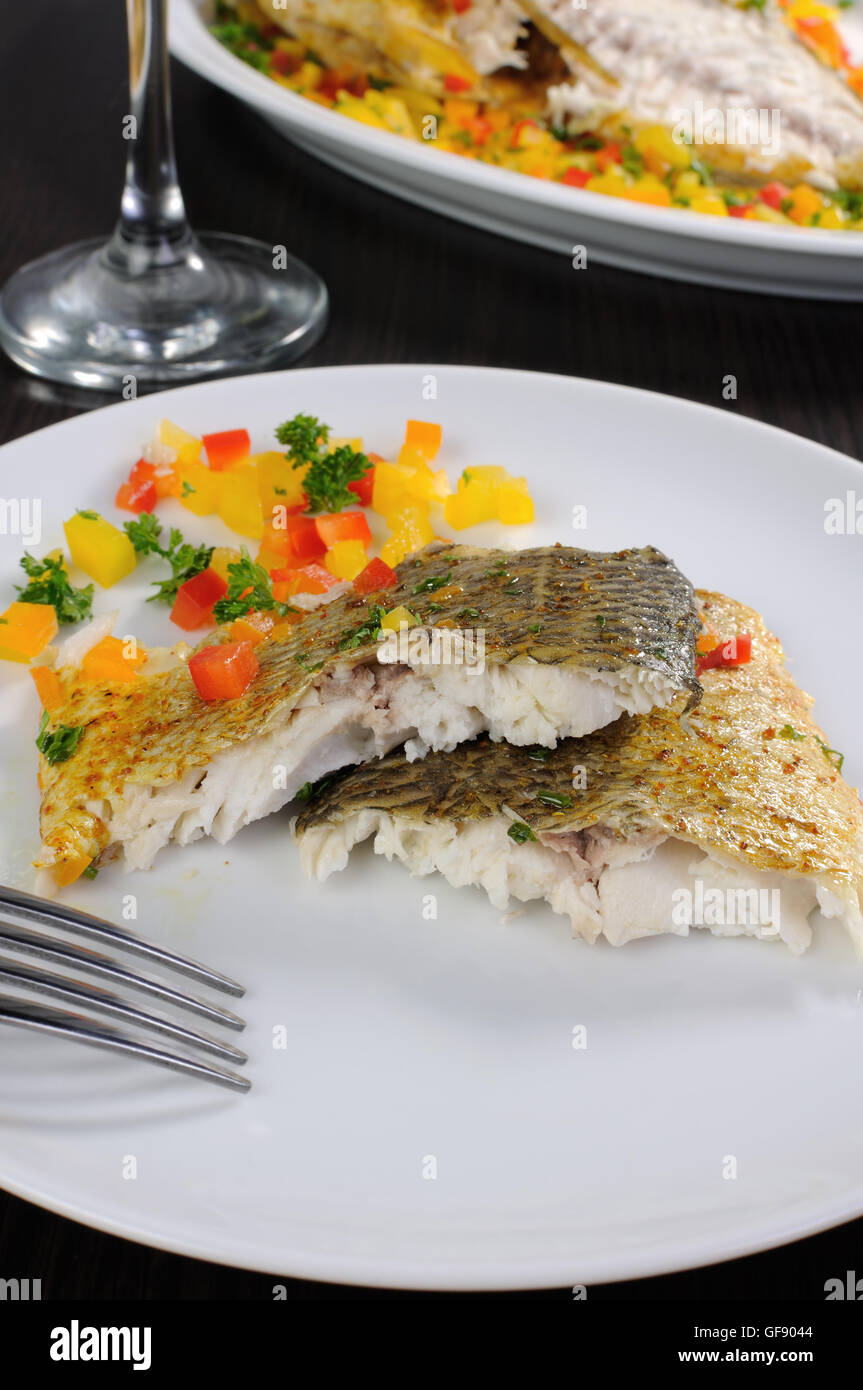 Slices of baked fish dorado with multi-colored pepper diced Stock Photo ...