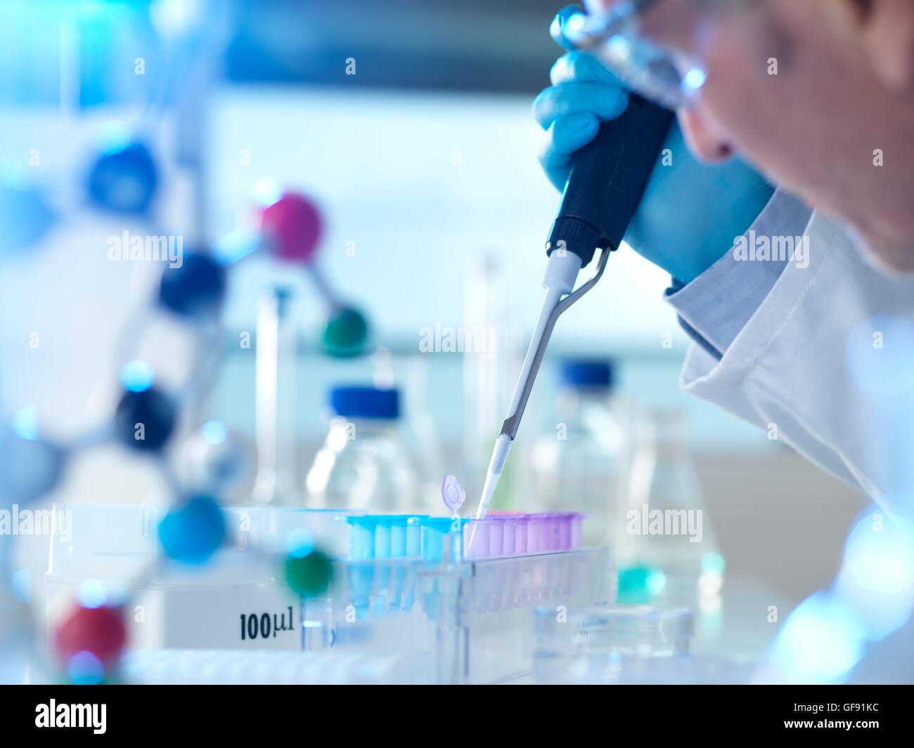 MODEL RELEASED. Scientist pipetting a chemical sample into a vial ...