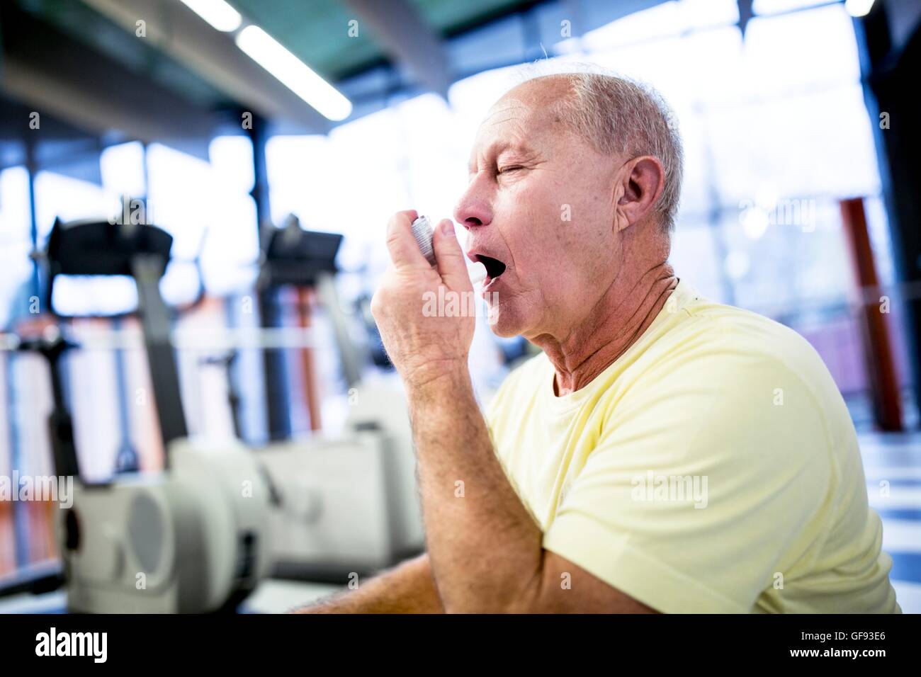 PROPERTY RELEASED. MODEL RELEASED. Senior man using asthma inhaler in ...