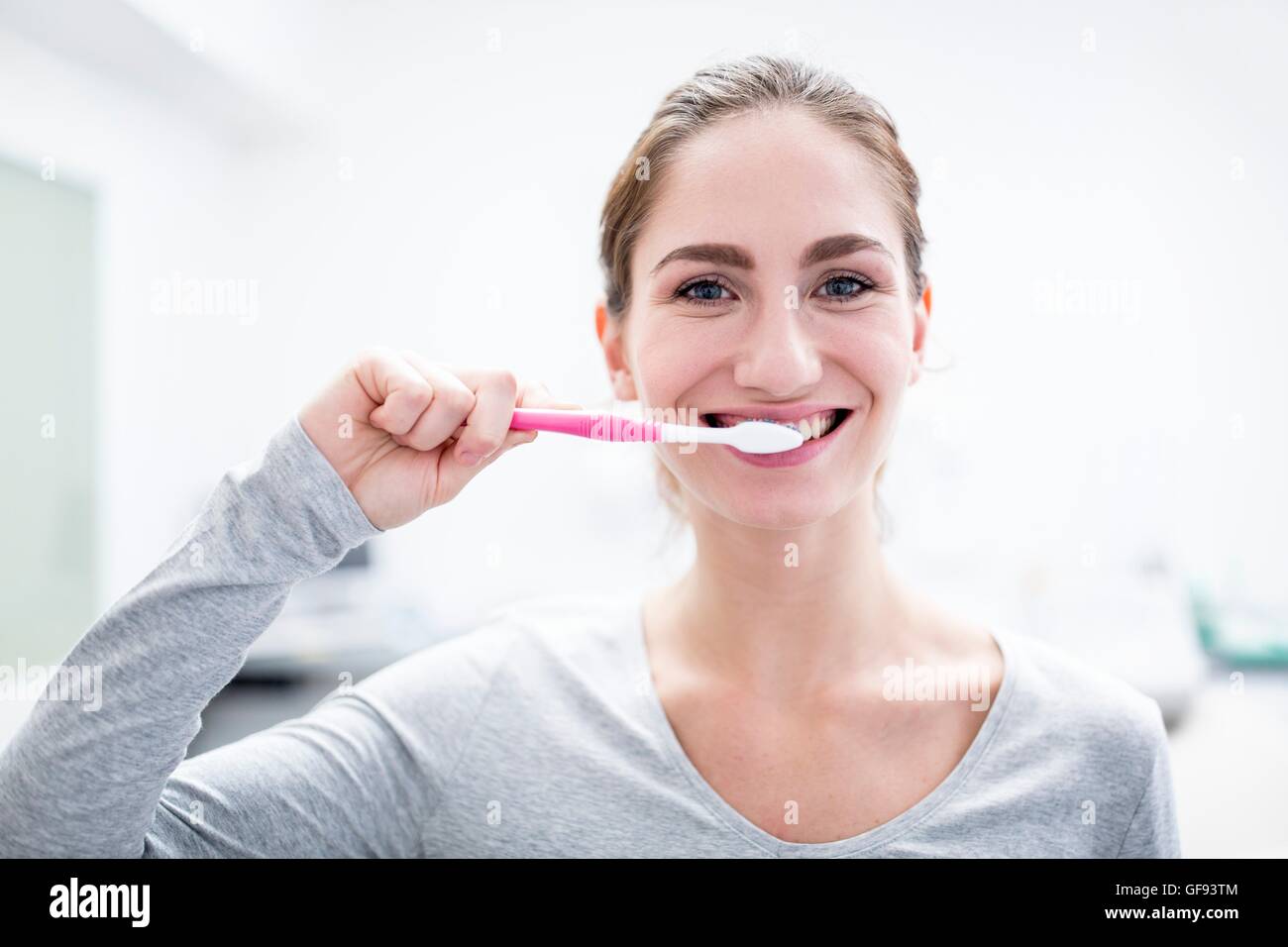 MODEL RELEASED. Young woman brushing teeth, portrait, close-up Stock ...