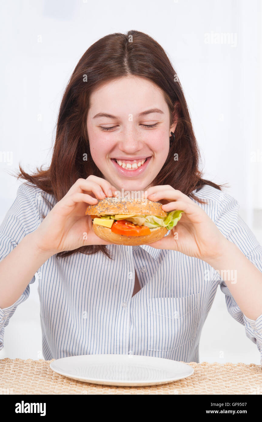 MODEL RELEASED. Young woman eating healthy sandwich, smiling Stock ...