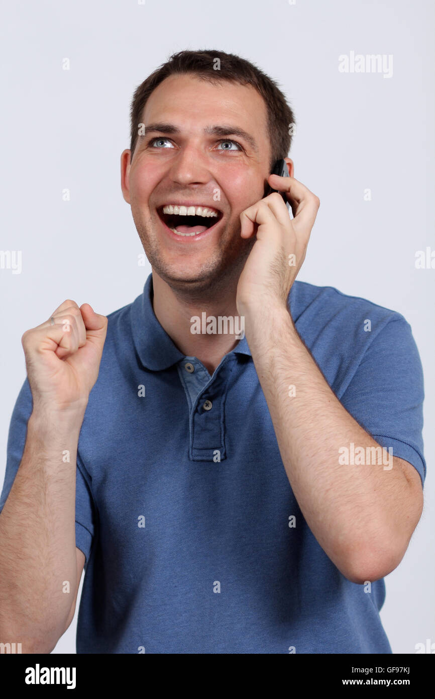 Smiling young man on his mobile phone against a white background Stock ...