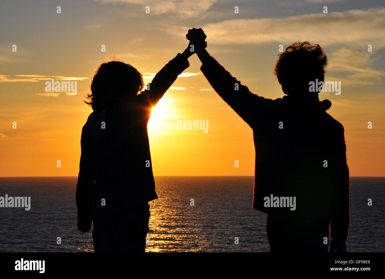 Silhouette of kids hanging by hands Stock Photo - Alamy